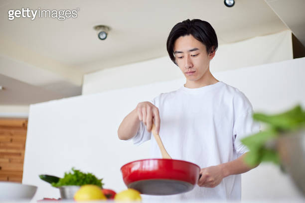 Young Japanese man cooking in the kitchen 이미지 (2101585224) - 게티이미지뱅크