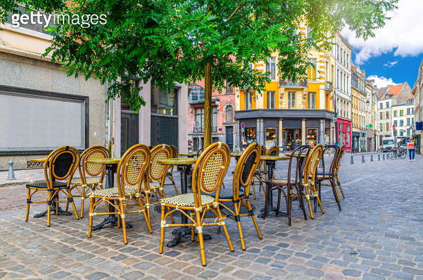 Street restaurant with wooden tables and chairs on cozy street, road ...