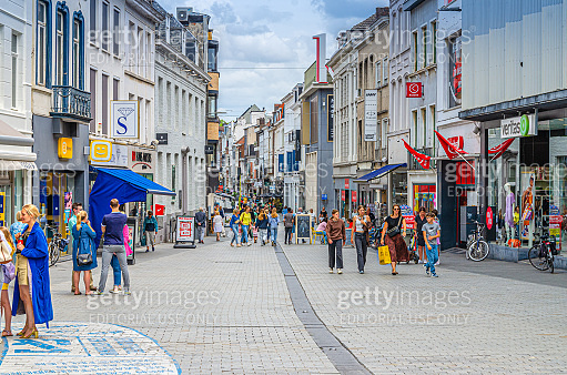 crowd of people tourists walking down pedestrian shopping street with ...