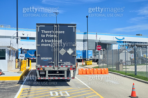 Amazon branded truck at logistics hub entrance with slogan ...
