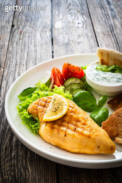 Seared chicken breast, pita bread and tzatziki on wooden table 이미지 ...
