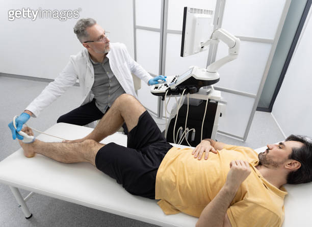Adult man lying on medical couch receives modern diagnosis of injured ...