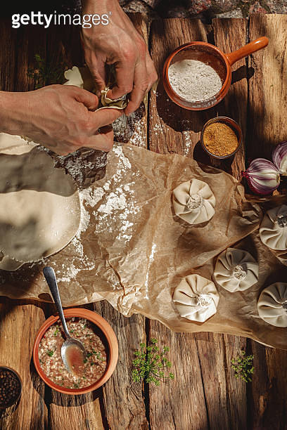Hands expertly mold khinkali, the traditional Georgian dumplings, in ...