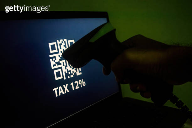 A barcode scanner is scanning a QR code displayed on a screen with the ...
