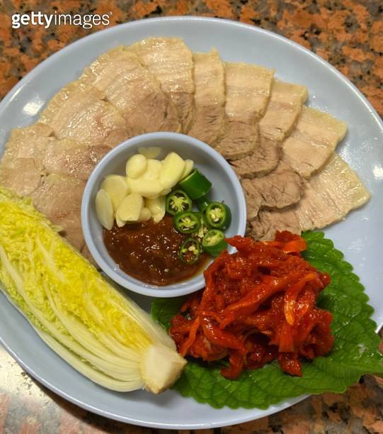 Tender slices of bossam, Korean boiled pork belly, served with fresh ...
